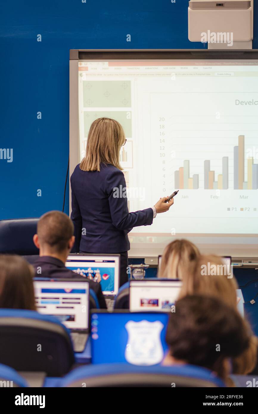 Professor presenting and giving a lecture about graphs to her students ...