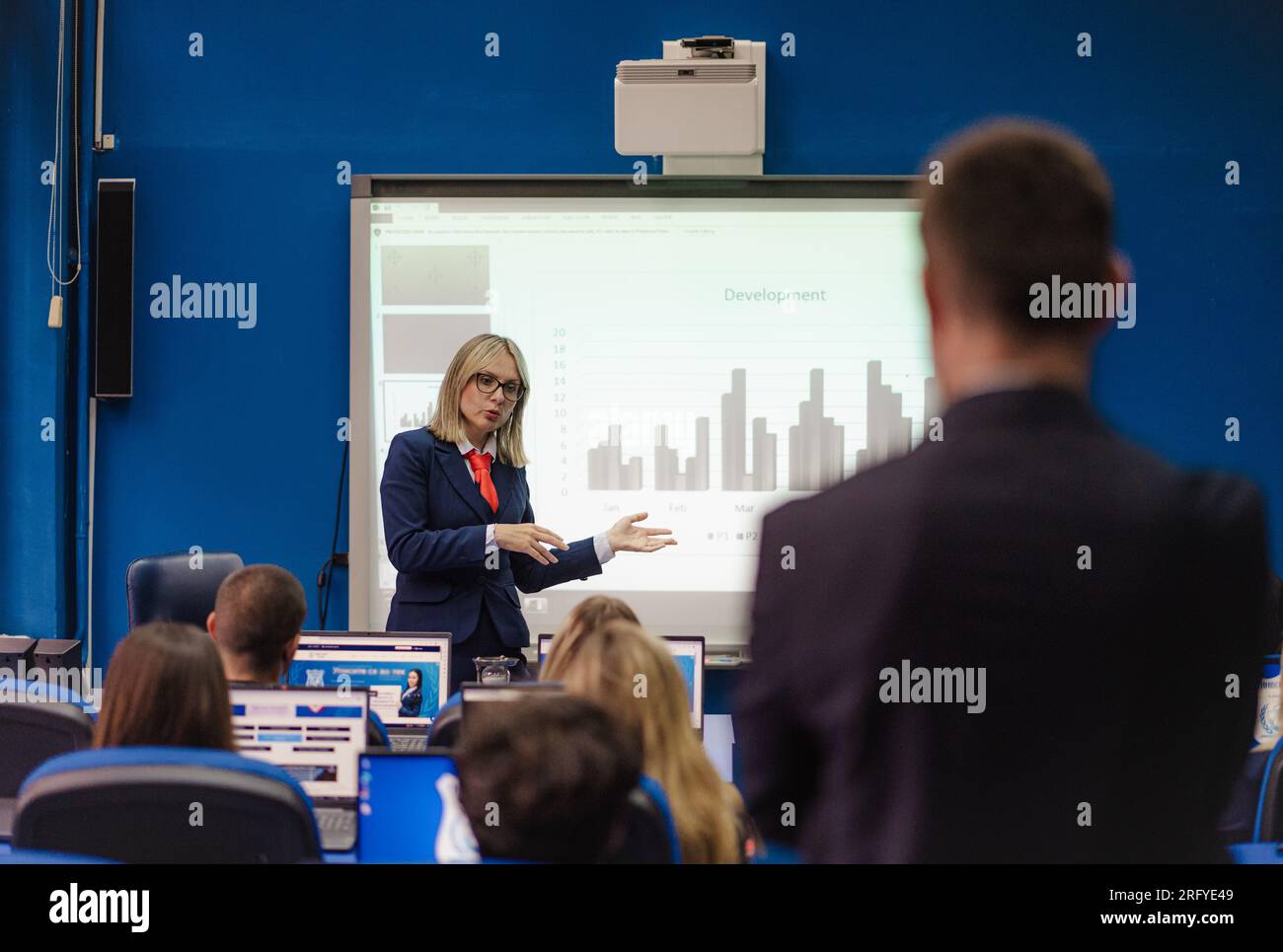 Professor presenting and giving a lecture about graphs to her students ...