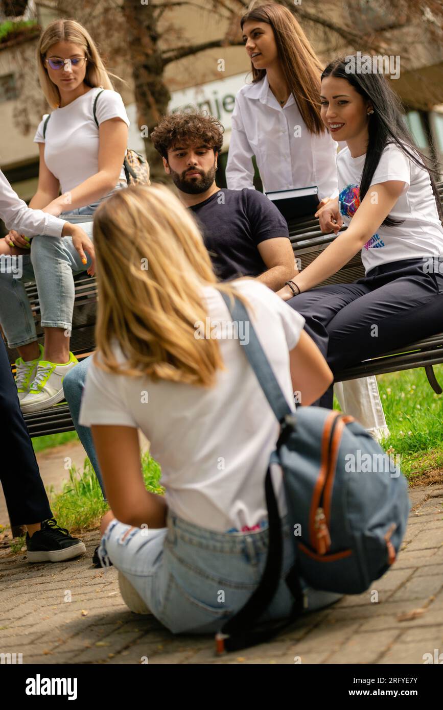 Group of classmates sitting down outside, talking and smiling Stock ...