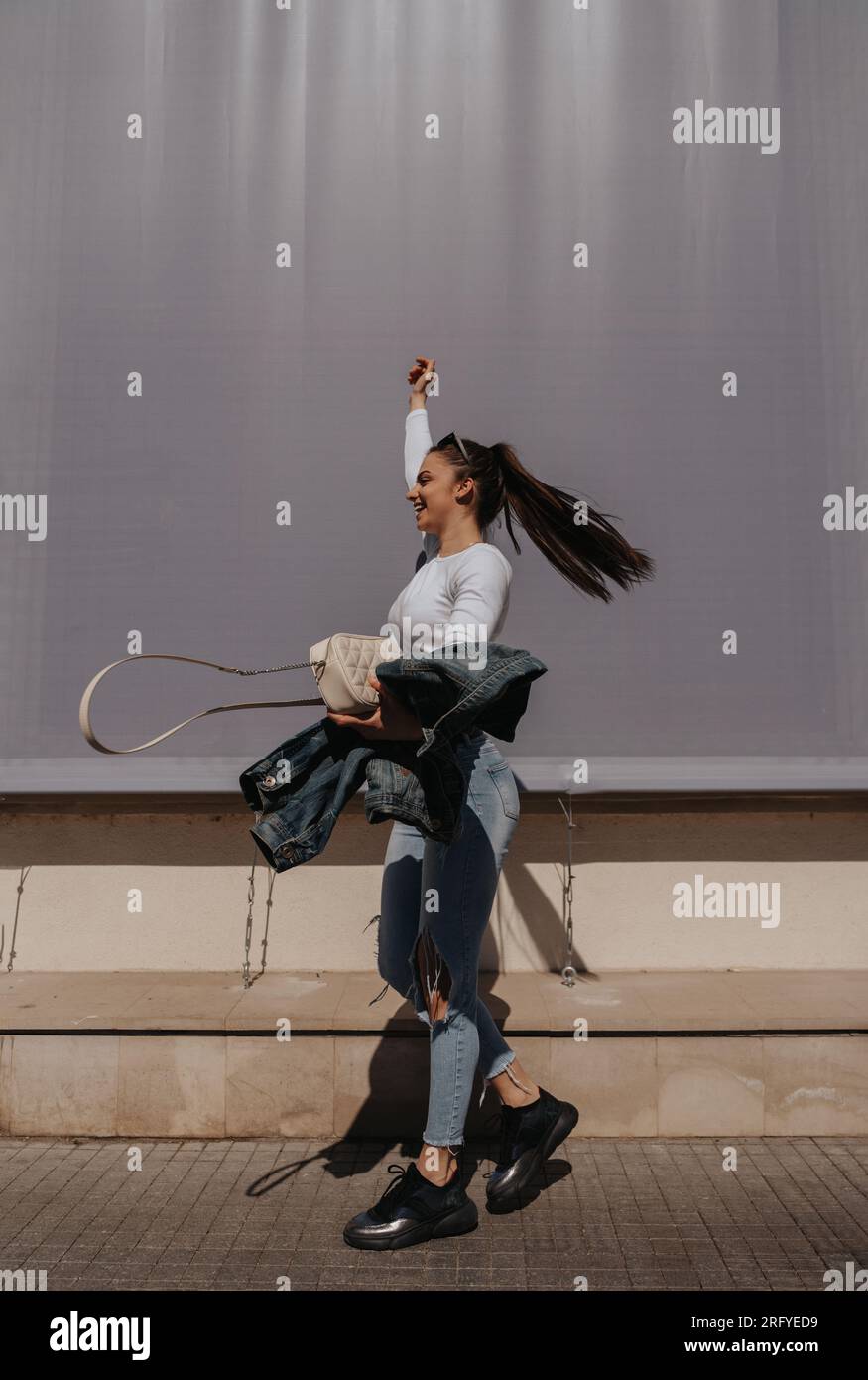 Beautiful brunette girl dancing and spinning in from of the big grey ...