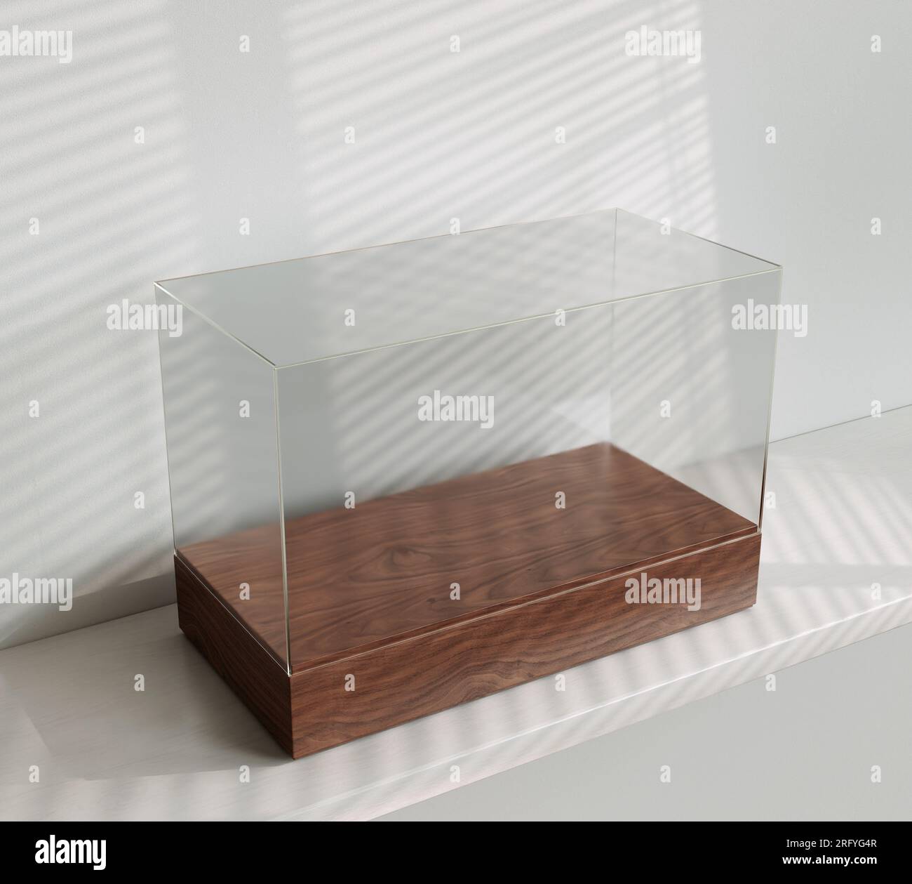 An empty glass display case with a wooden base sitting on a white shelf ...