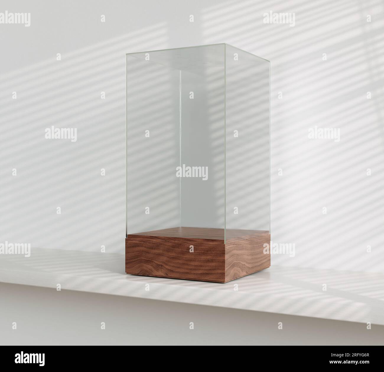 An empty glass display case with a wooden base sitting on a white shelf ...