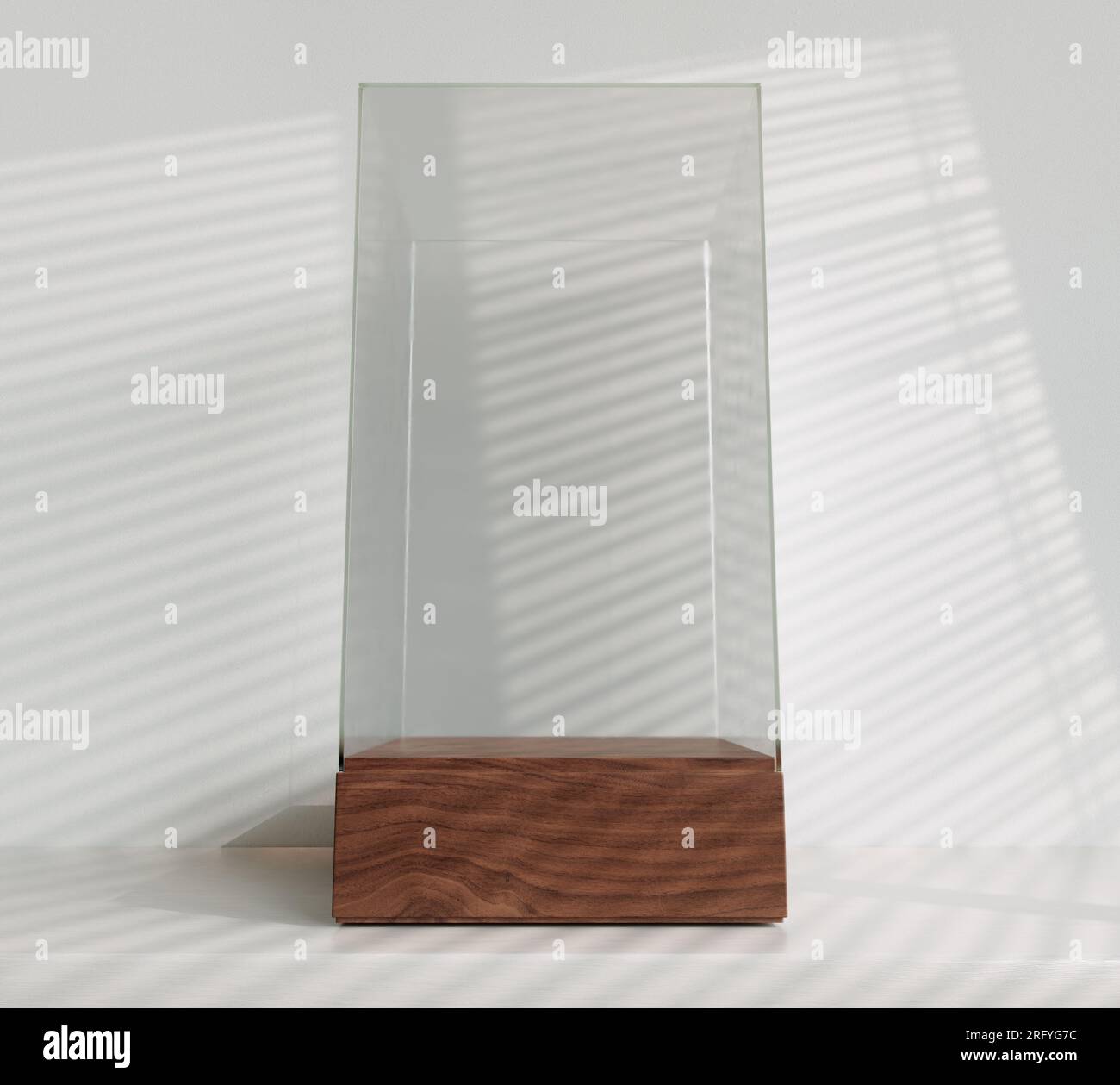 An empty glass display case with a wooden base sitting on a white shelf ...