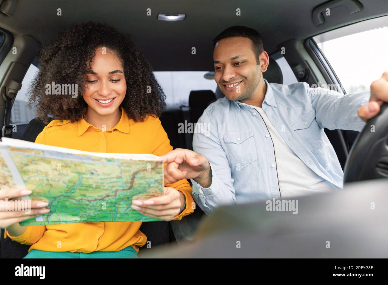 Arabic Driver Pointing At Map In Woman's Hands In Auto Stock Photo - Alamy