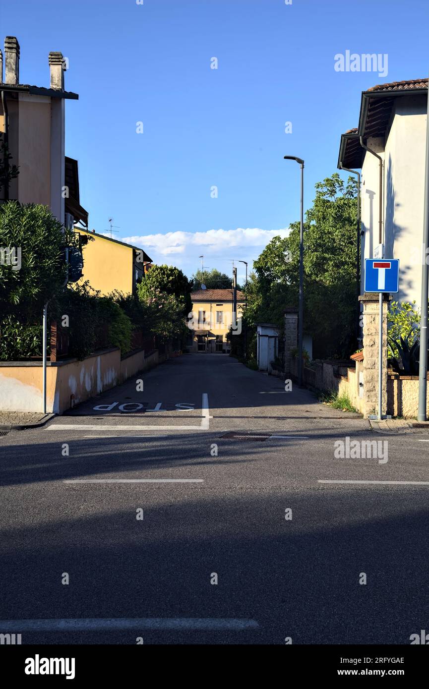 Dead end street seen from a crossroads in an italian town at sunset ...
