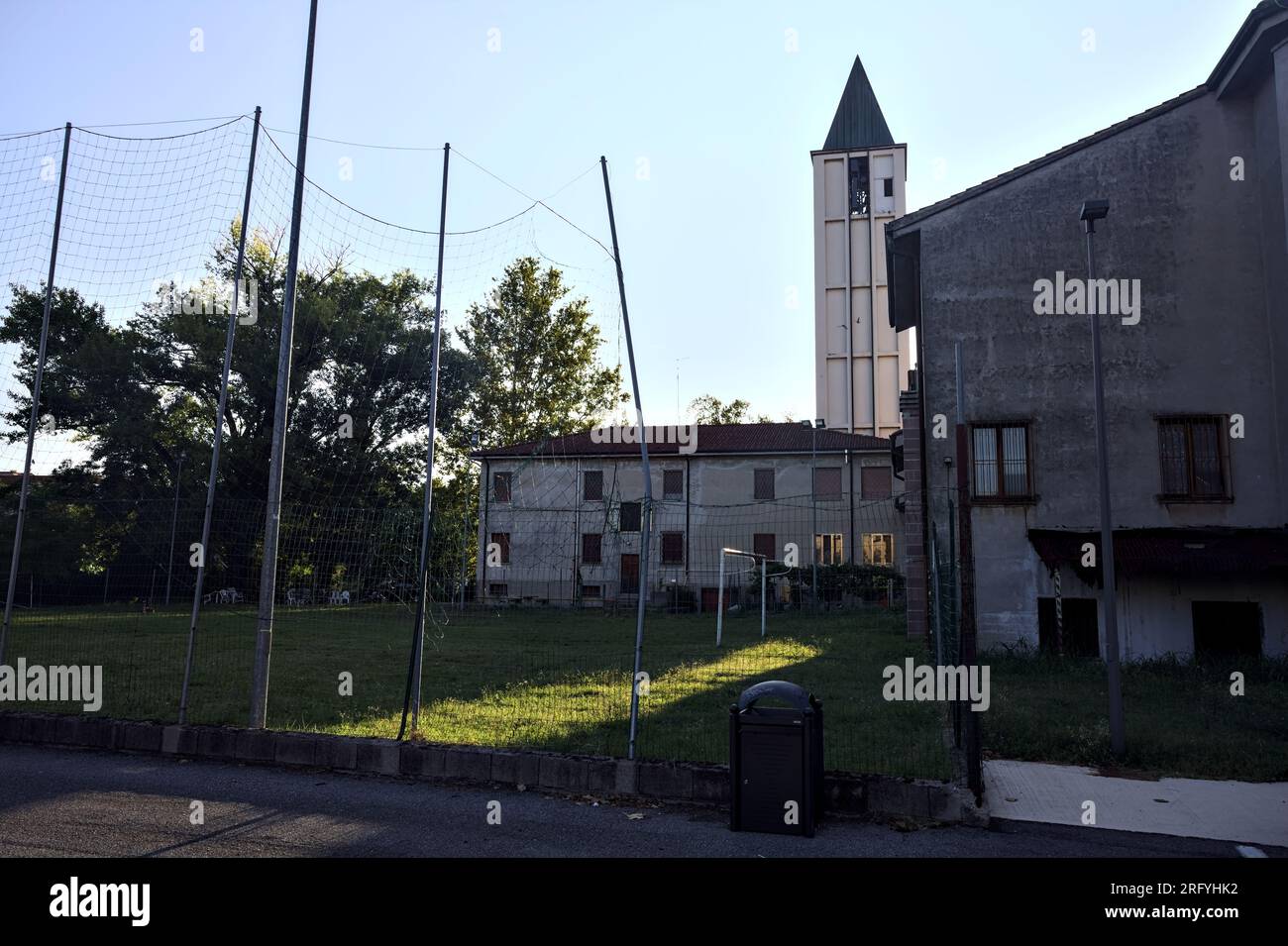 Field behind a church and the entrance of a path in the italian ...