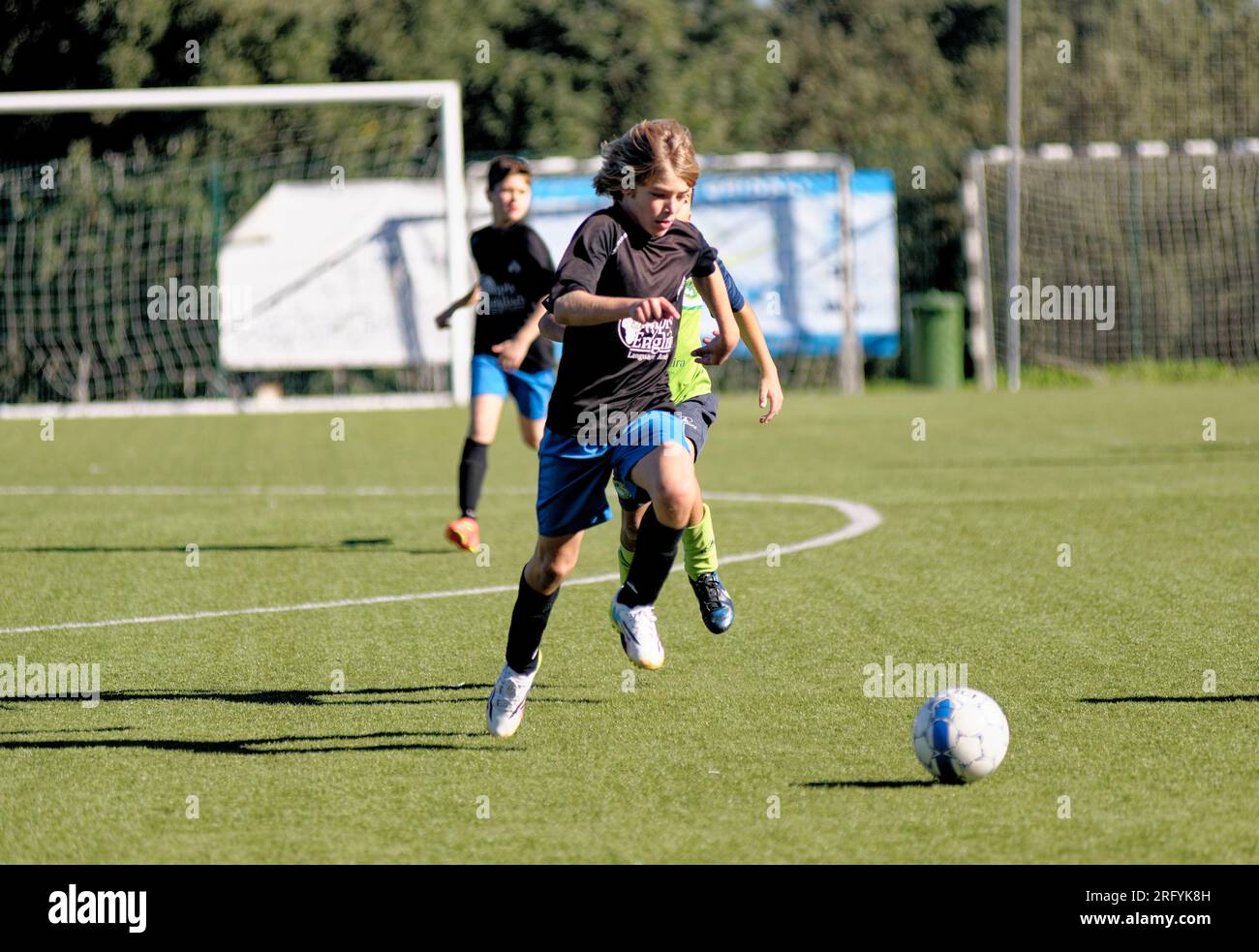 Young kids children teenage boys playing football soccer game sports in ...