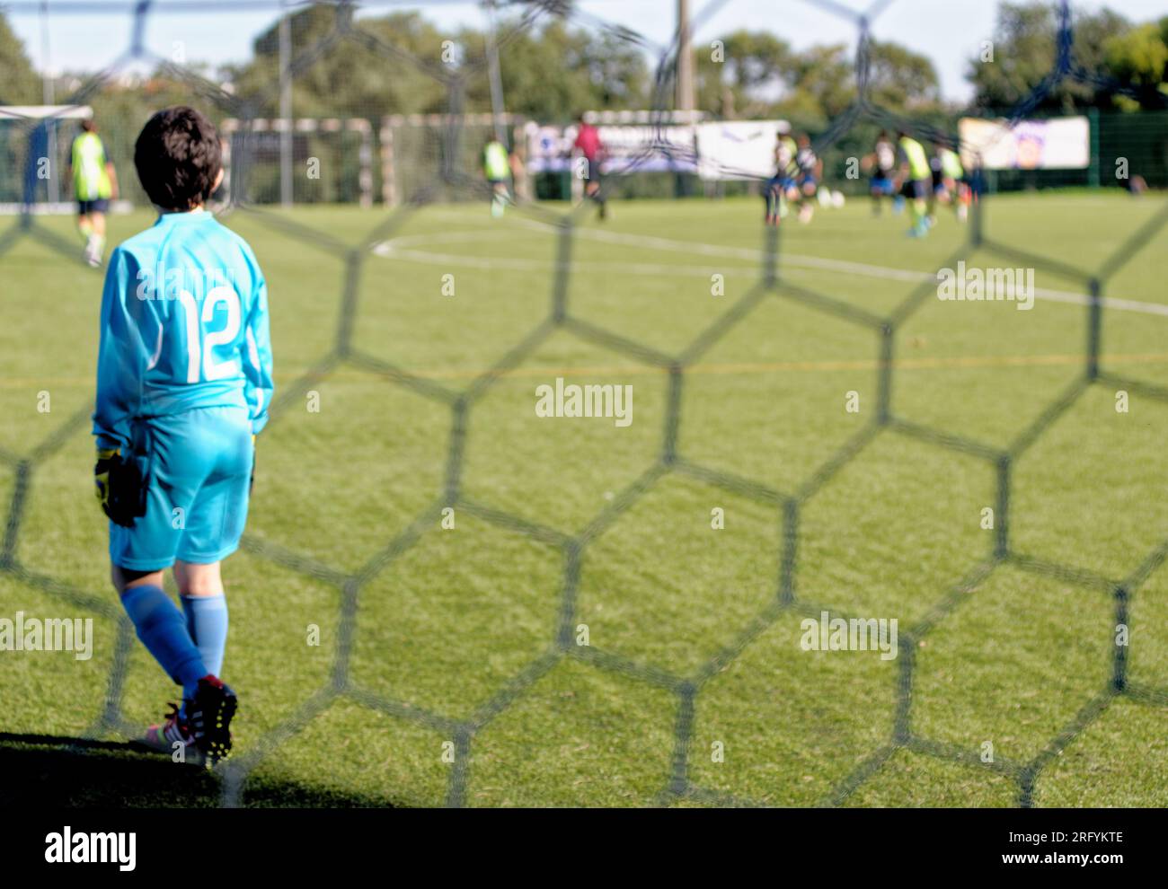 Young goalkeeper kid teenage boy playing football soccer game sports in ...