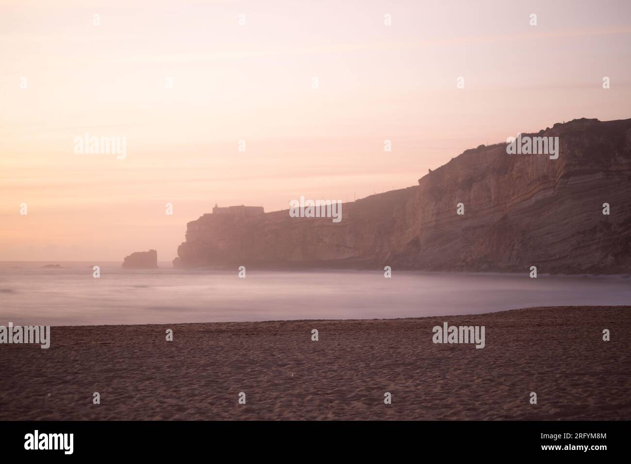 Nazaré's mesmerizing promontory: Sunset's golden embrace paints the ...