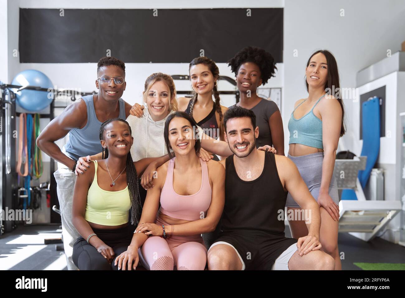 multicultural group of fitness people looking at camera and smiling at ...