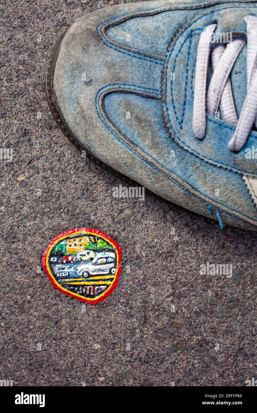 London, UK. Tiny work of art painted on a discarded piece of chewing ...