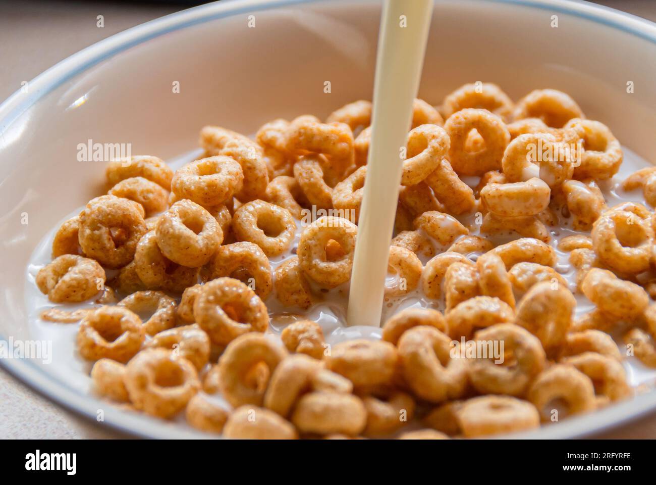 A close-up captures the moment a stream of milk cascades onto a bowl of ...
