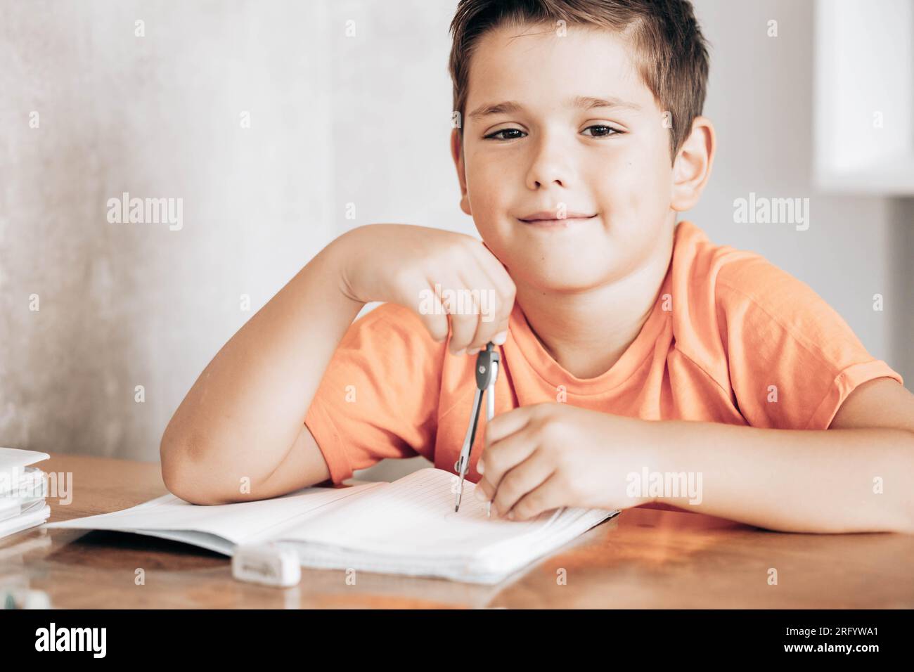 Little school boy doing homework with spring divider, sitting at the ...