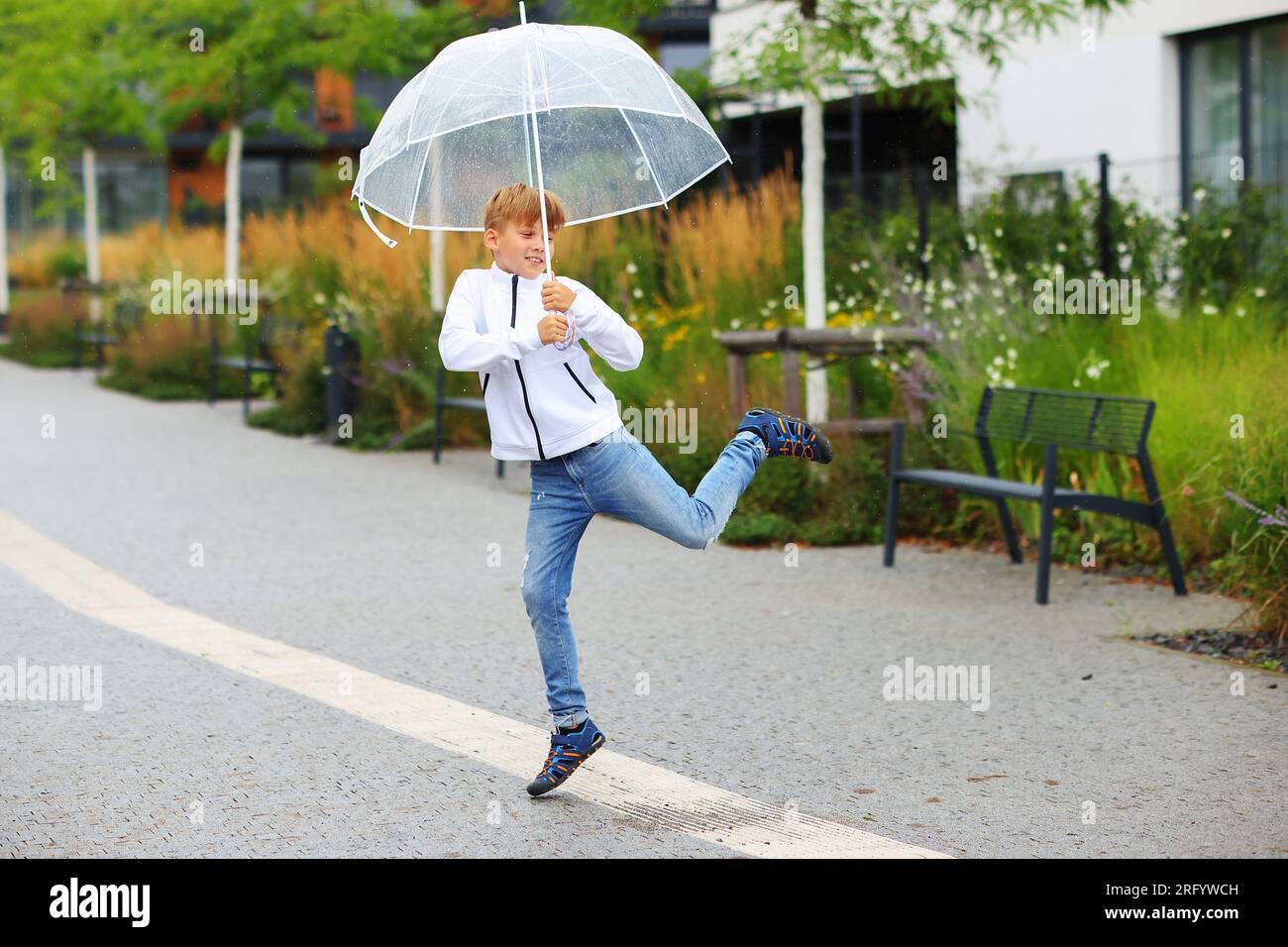 Boy holding an umbrella with raindrops. Happy little child boy having ...