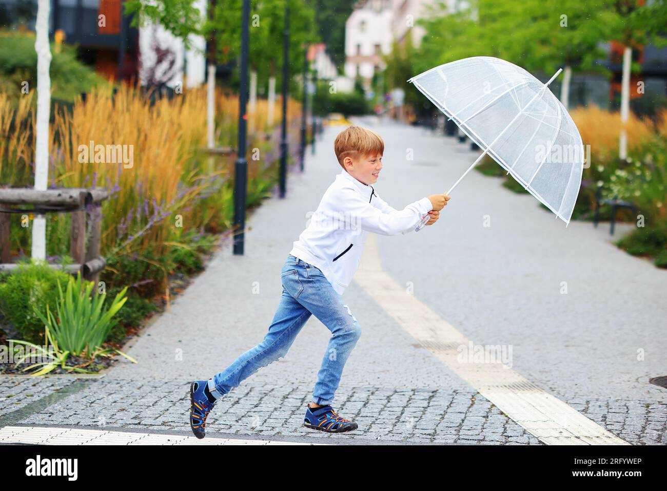 happy boy running under rain Stock Photo - Alamy