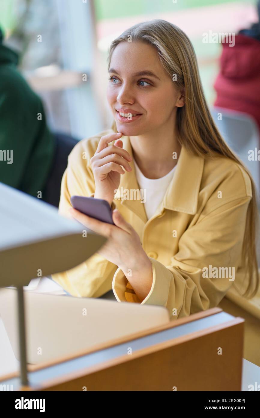 Teenage girl gen z student using cell phone looking away. Vertical ...