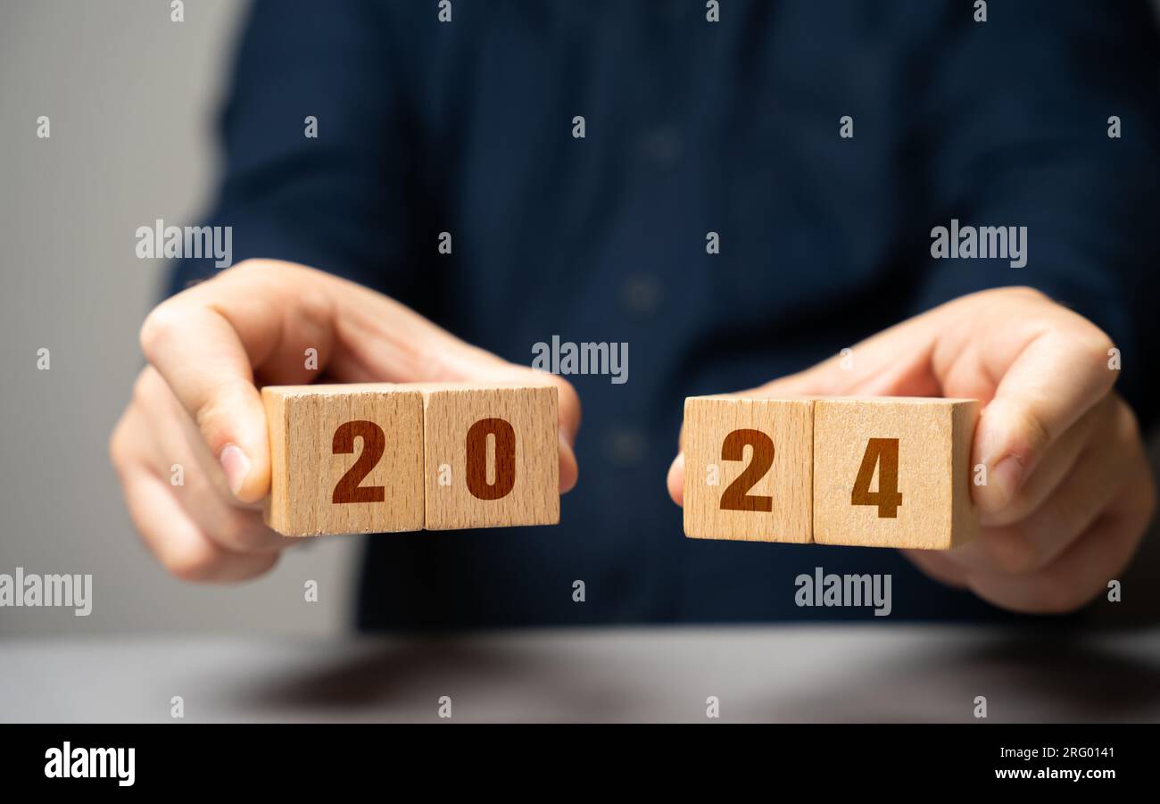 Businessman holding wooden blocks 2024. Business plan and strategy ...