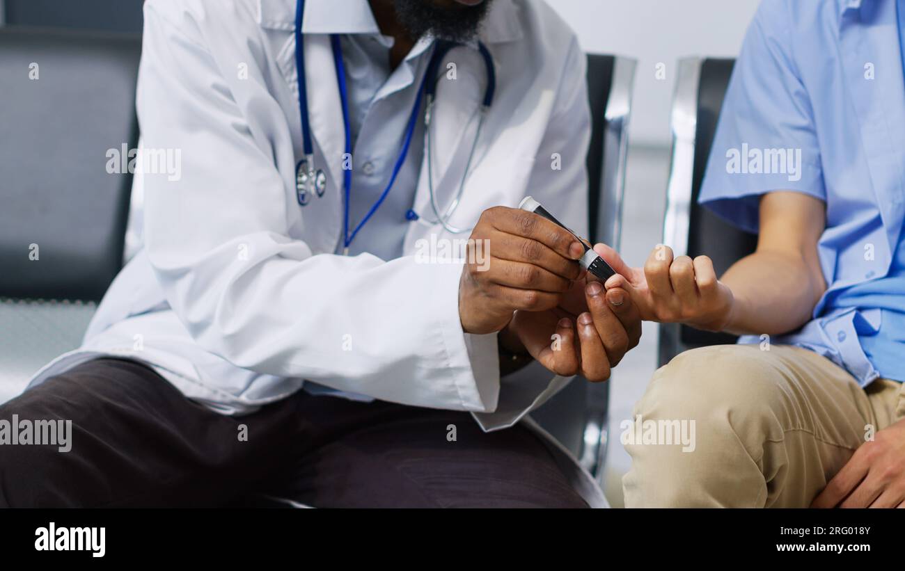 Specialist measuring insulin and glucose level using glucometer, doing ...