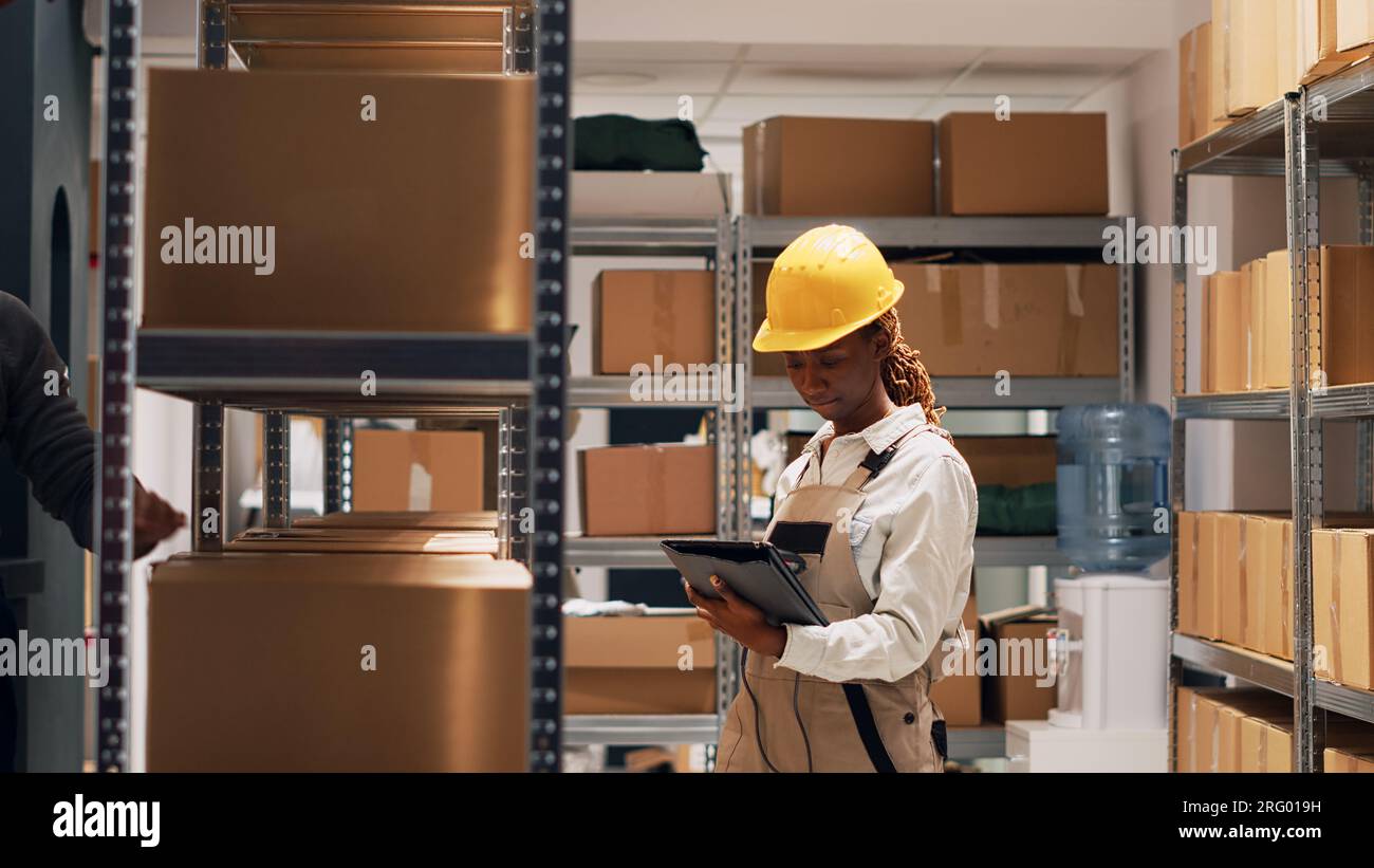 Depot employee pointing scanner at cardboard boxes, scanning barcodes ...