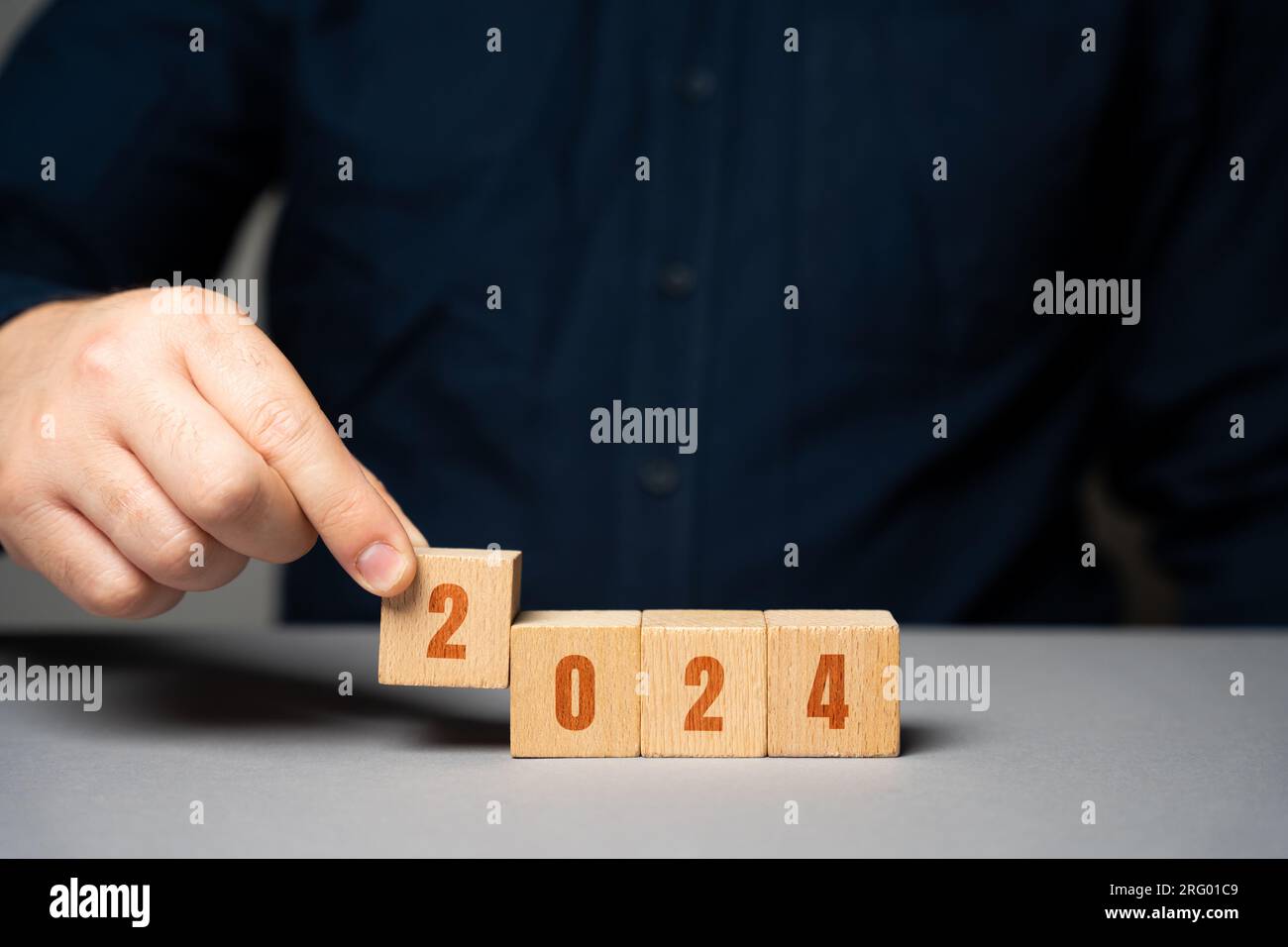 Businessman holding wooden blocks 2024. Business plan and strategy ...
