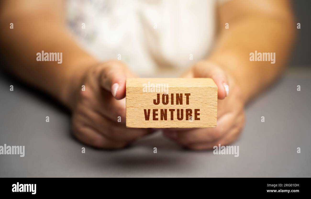 Joint venture on blocks concept. JV is a business entity created by two ...