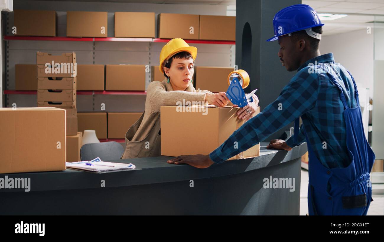 Female supervisor scanning products with barcodes in storage room ...
