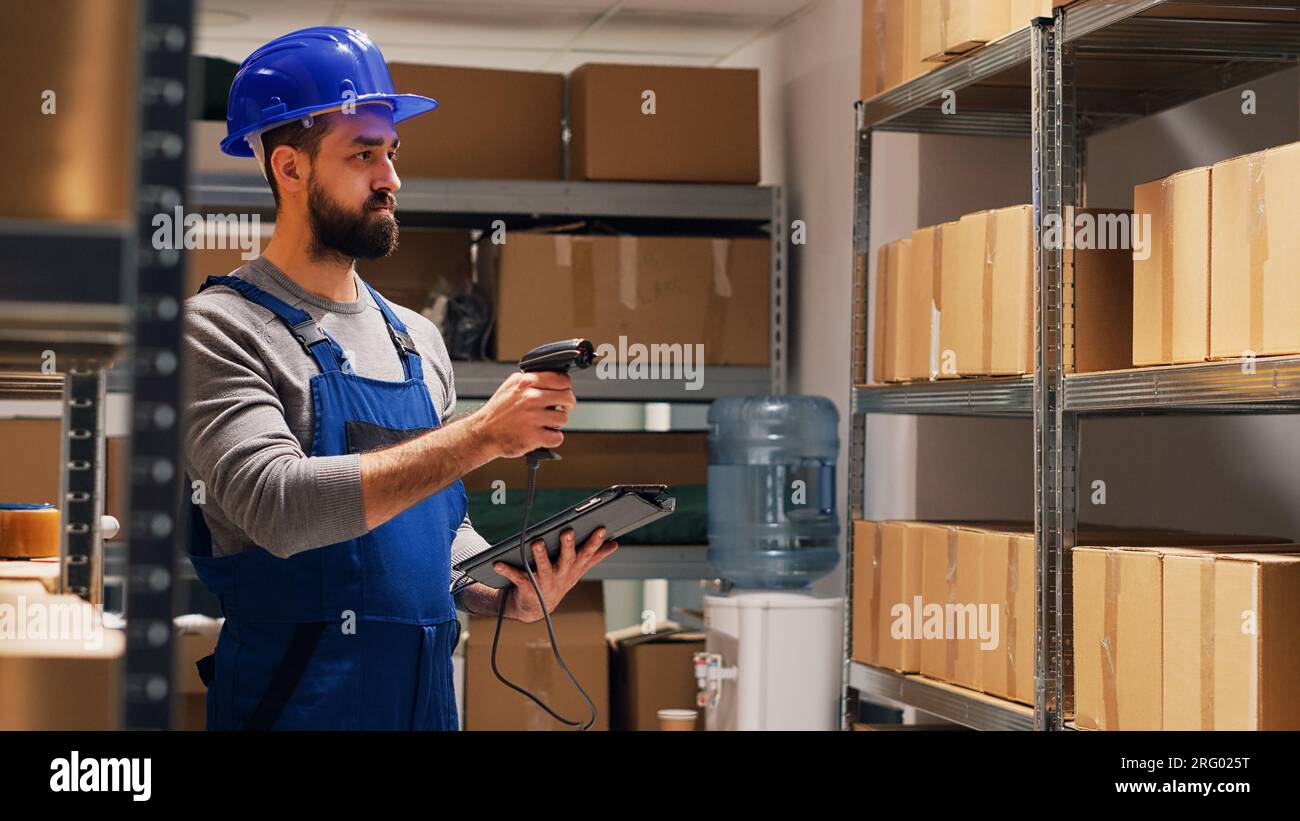 Male supervisor scanning barcodes on packages in depot, pointing ...