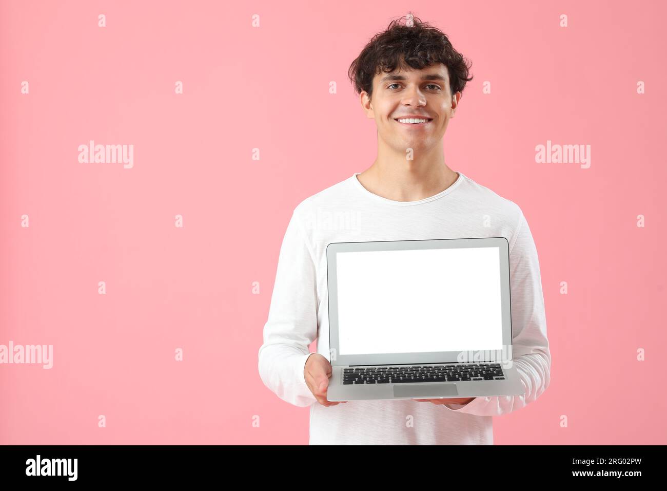 Male programmer with blank laptop on pink background Stock Photo - Alamy