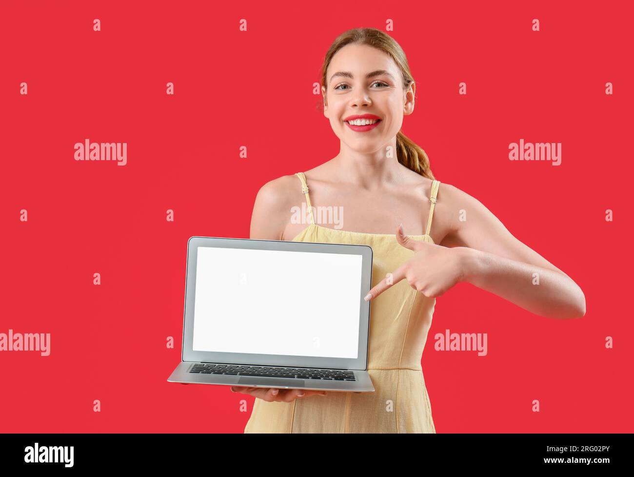 Female programmer pointing at blank laptop on red background Stock ...