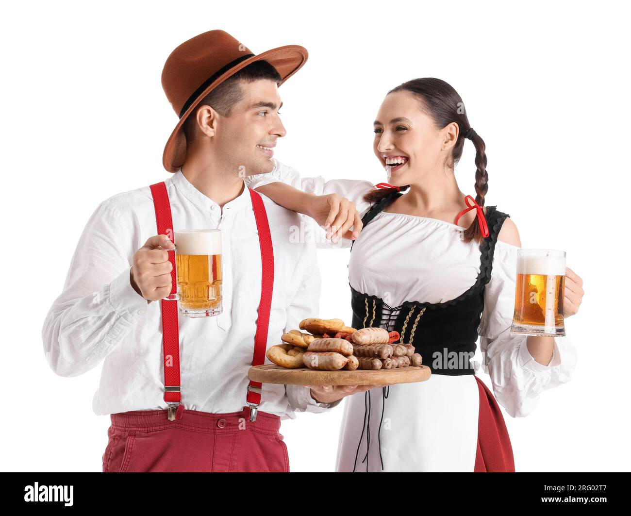 Young couple in traditional German clothes with beer and snacks on ...