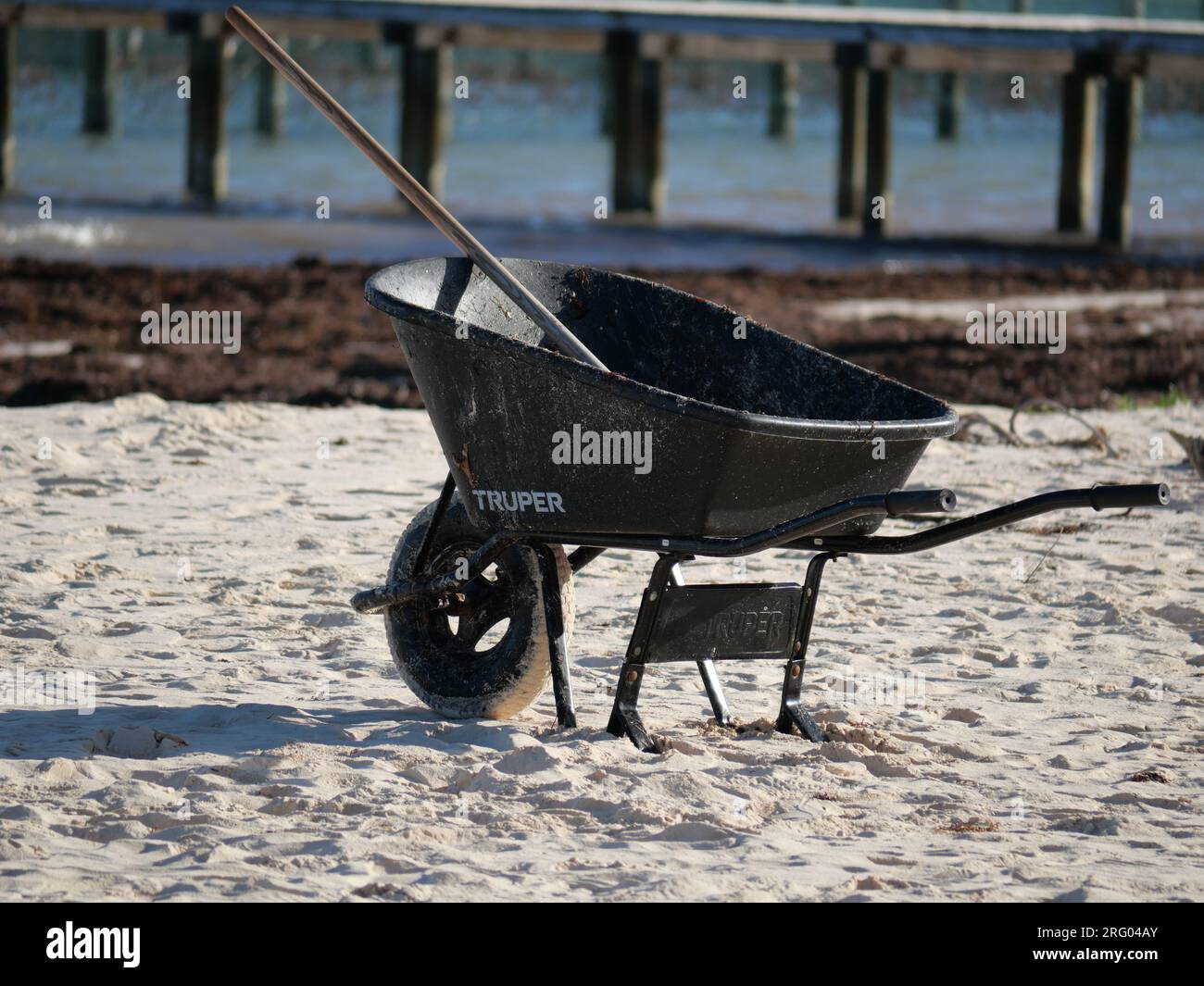 Wheelbarrow on a beach Stock Photo - Alamy