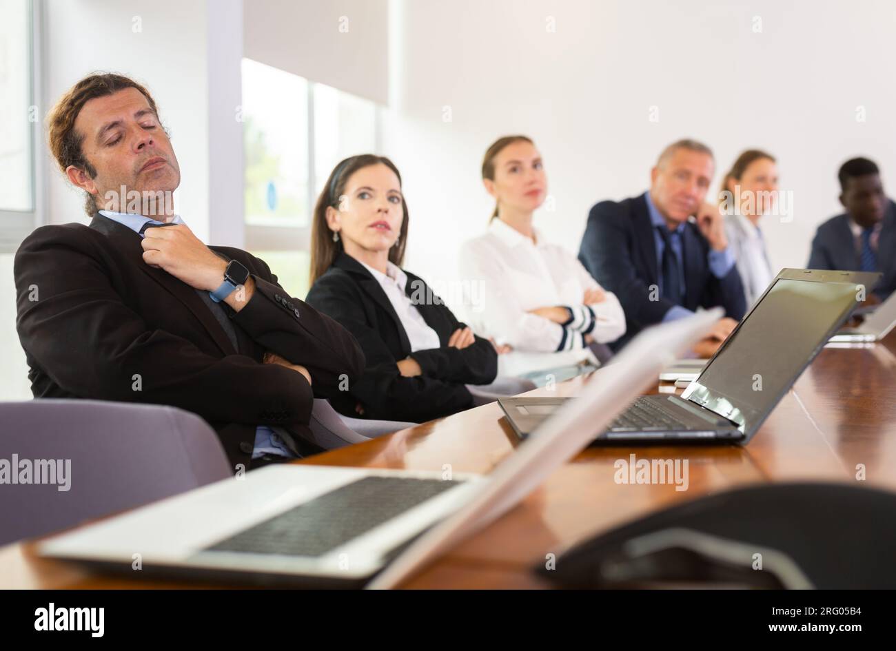 Tired businessman fell asleep at a business meeting in negotiation room ...