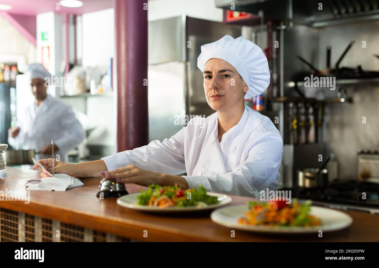 Chef checking orders and giving out meal Stock Photo - Alamy