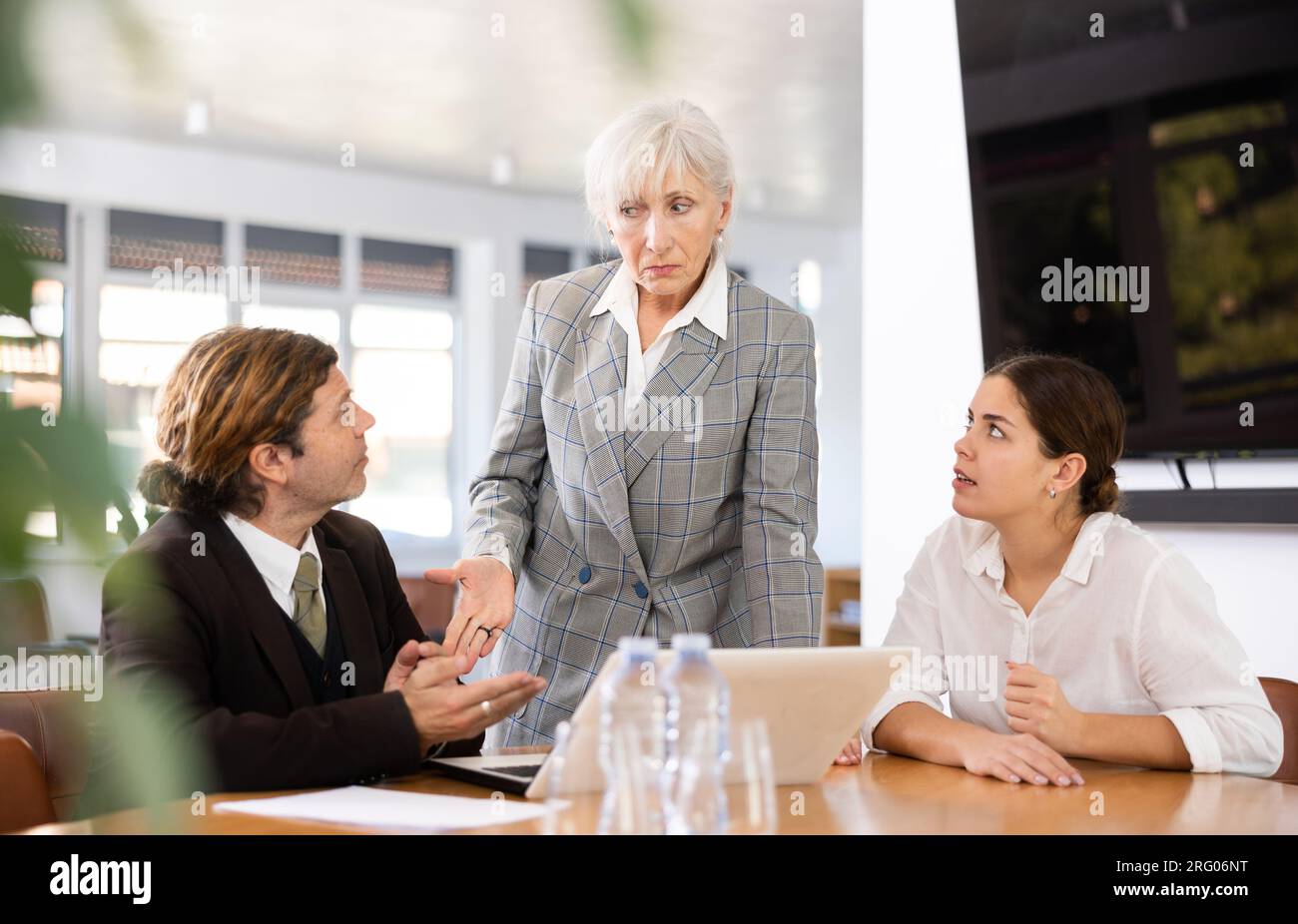 Strict senior female boss conducting work meeting with subordinates ...