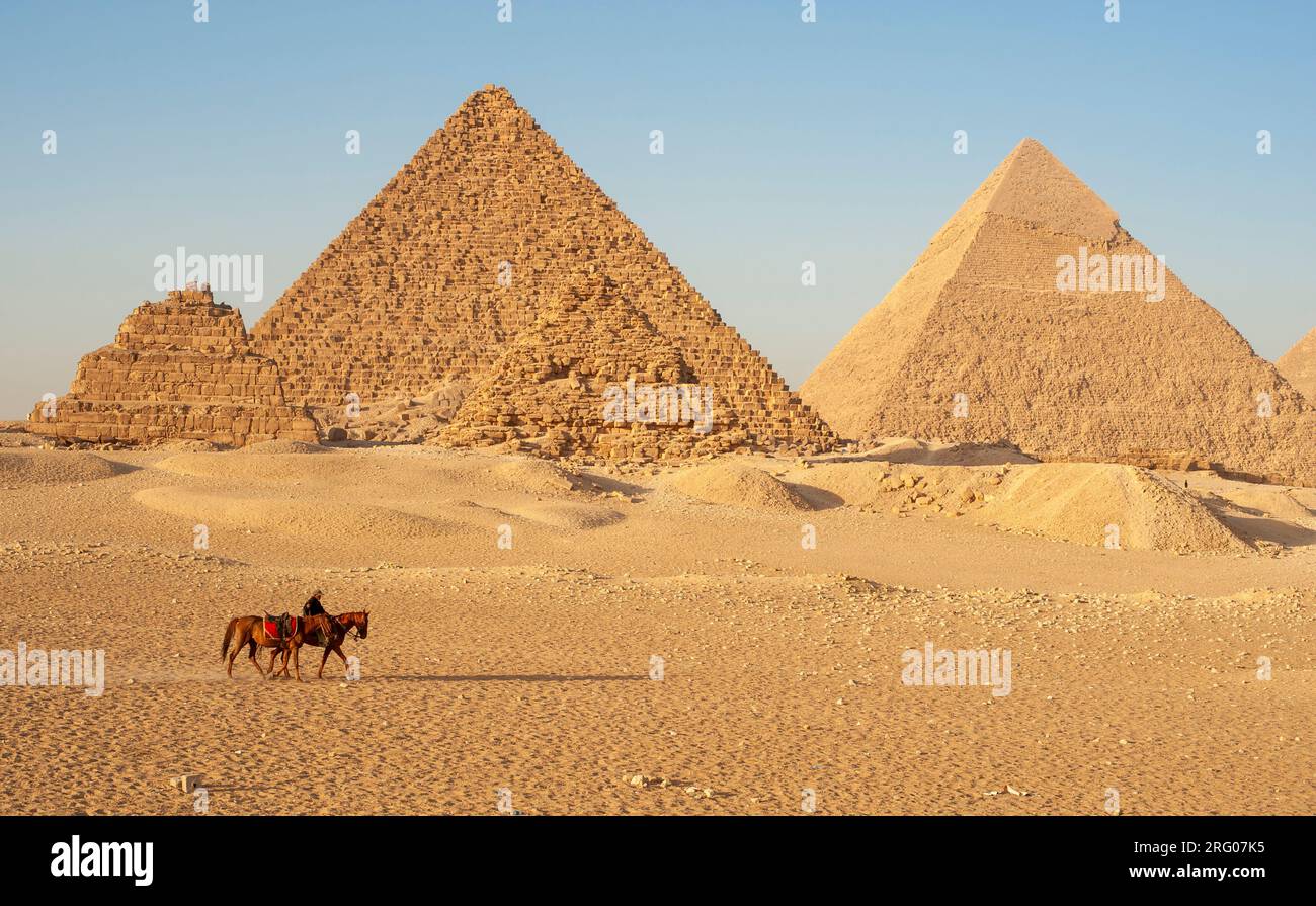 Africa, Egypt, Giza. A horse and rider at the great pyramids of Giza ...