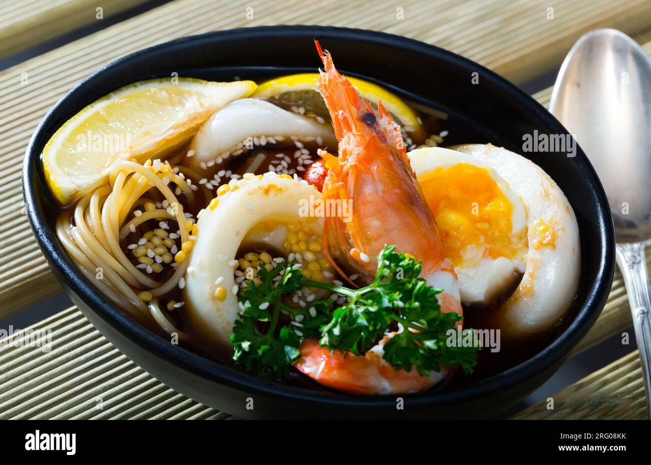Spicy pan-Asian soup boiled with squid, shrimp, egg noodles Stock Photo ...