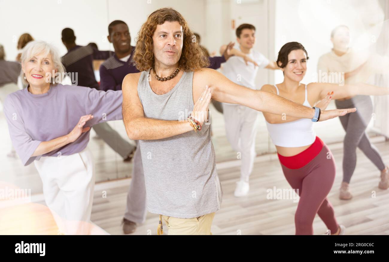 Happy caucasian man learning new modern dance in group dance lesson ...
