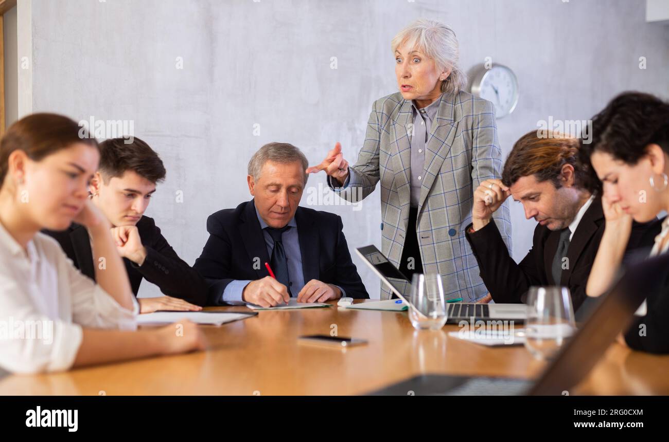 Elderly female boss expresses dissatisfaction with the work of top ...