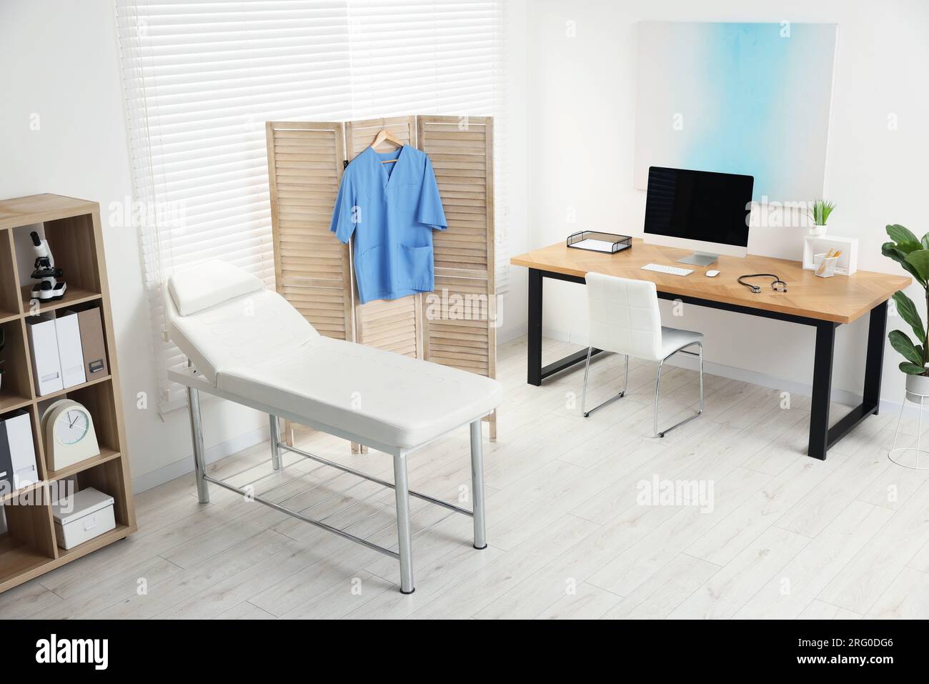 Modern medical office with doctor's workplace and examination table in ...