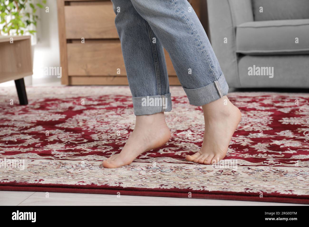 Woman standing on carpet with pattern at home, closeup Stock Photo - Alamy