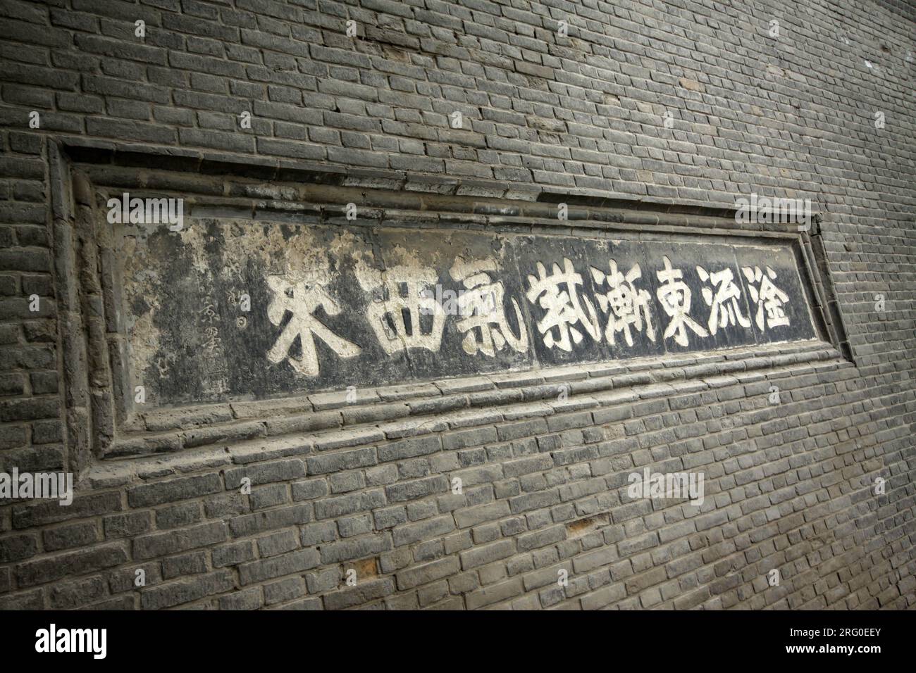 Classical text sculpture in the old grey wall in a park, north china ...