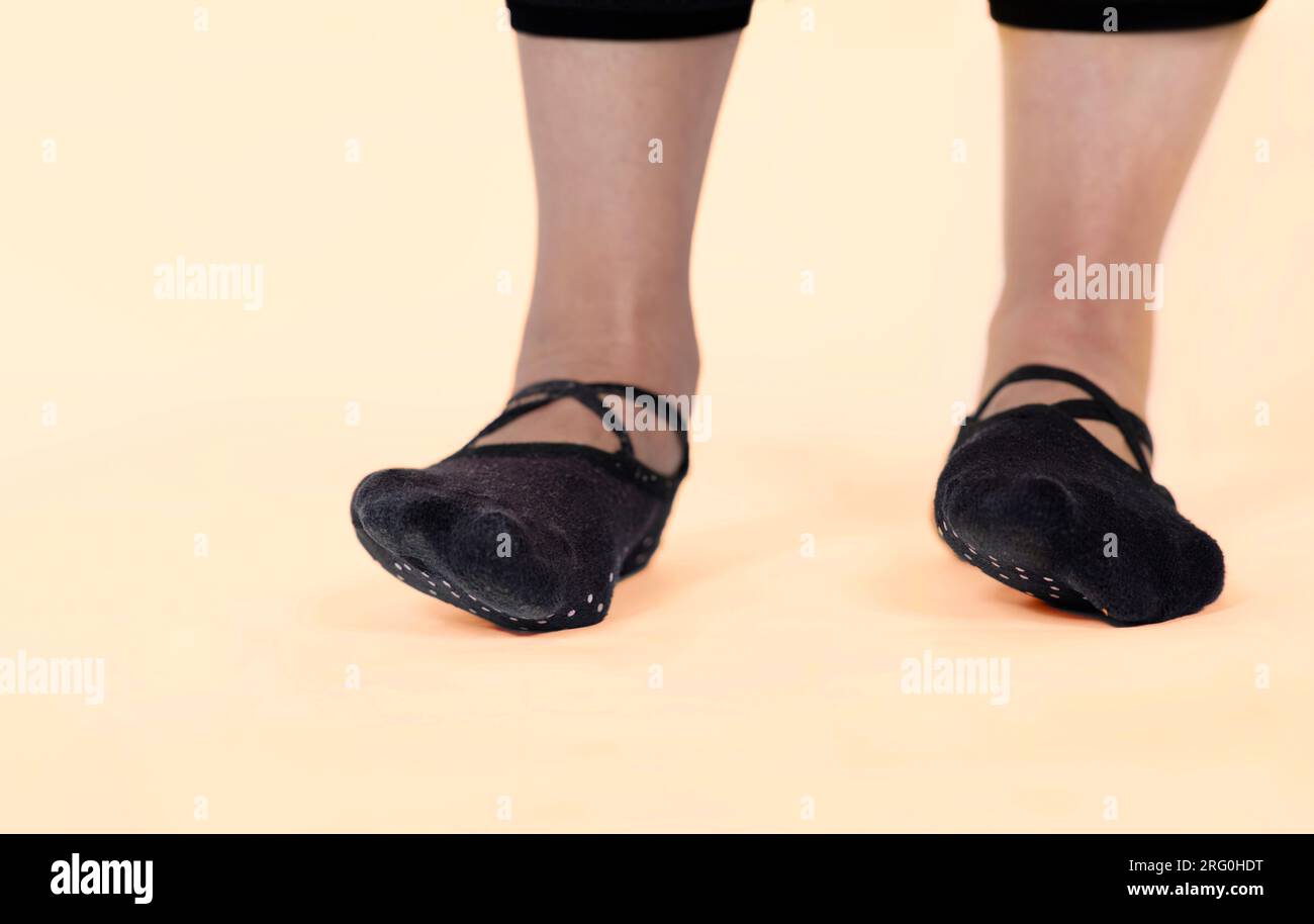 Woman wearing pilates socks, non-slip, doing trauma releasing exercises ...