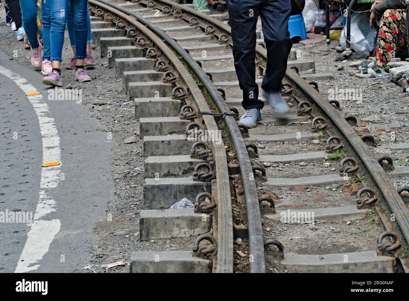 person walking through railway tracks in Darjeeling Stock Photo - Alamy