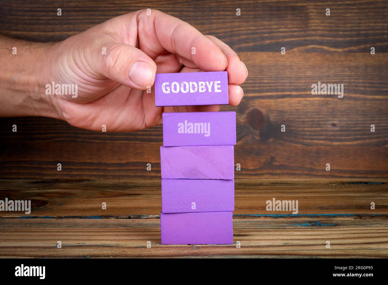 Goodbye Concept. Purple blocks with text in a pile on a wood texture ...