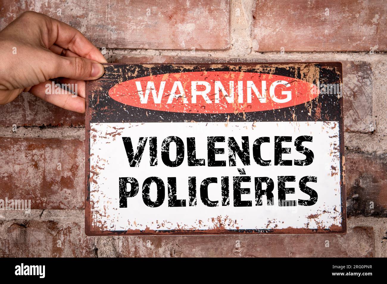 POLICE VIOLENCE. French text on warning sign. Red brick background ...