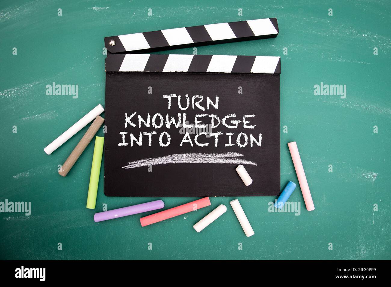 Turn knowledge into action. Motivational reminder text on a chalk board ...