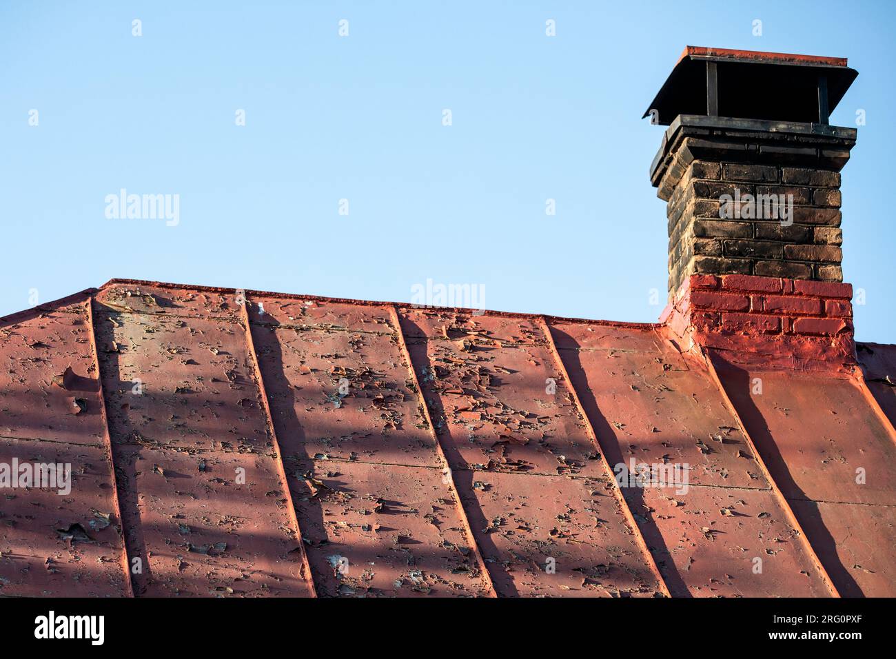 Old painted metal roof. Peeling paint and an old brick chimney Stock ...