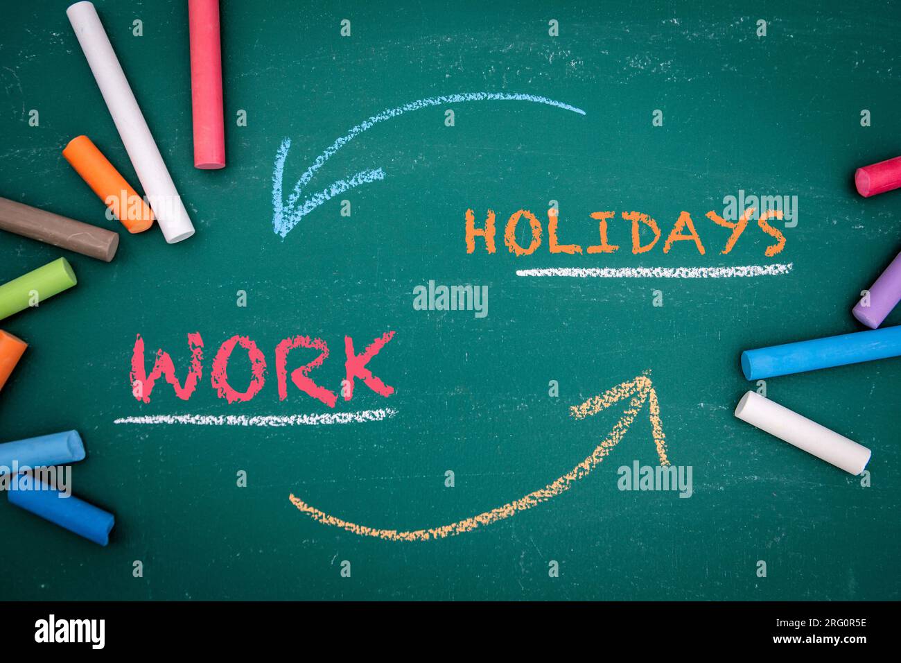 WORK HOLIDAYS Concept. Colored pieces of chalk and text on a green ...