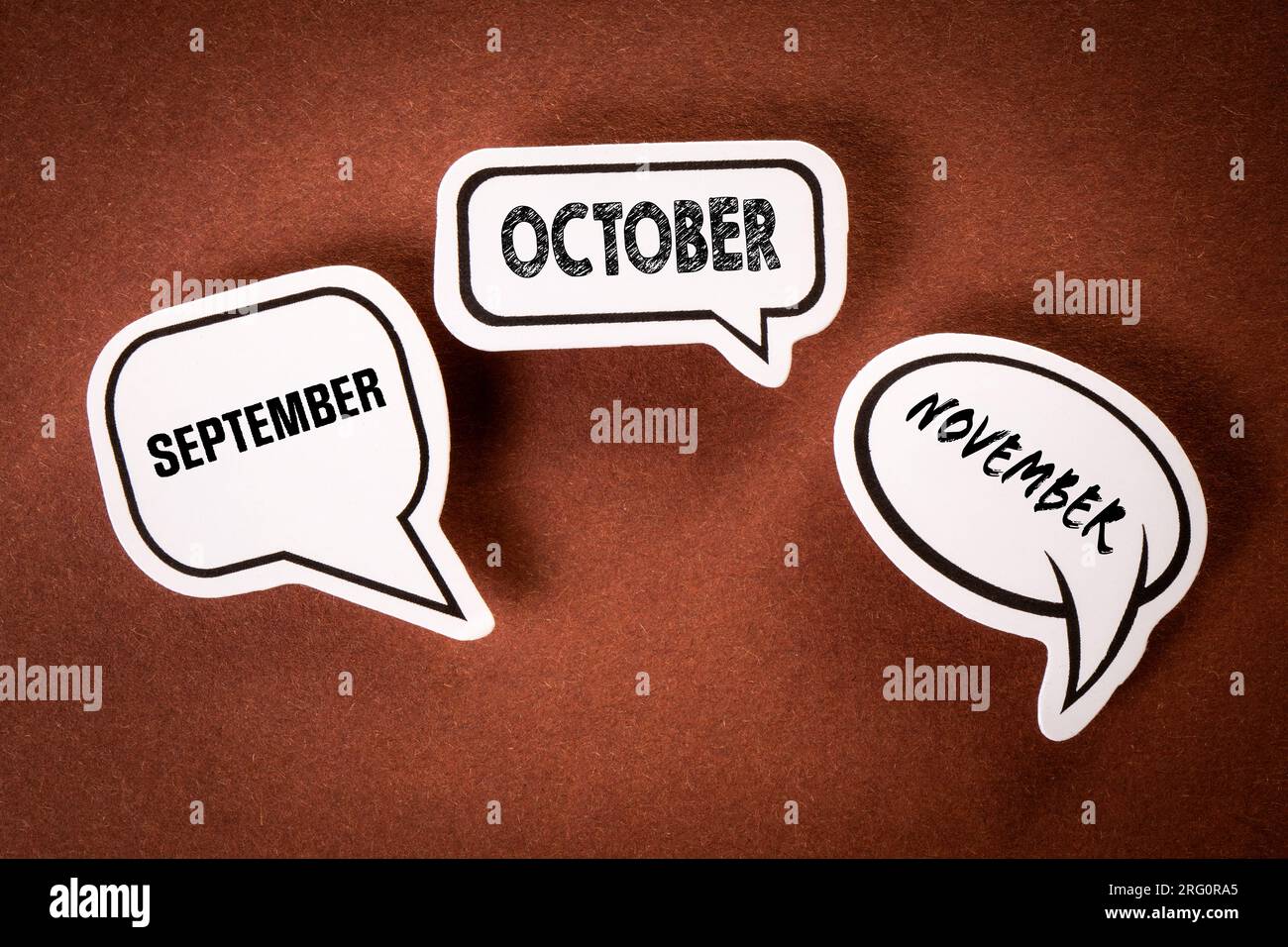 SEPTEMBER OCTOBER NOVEMBER. Three speech bubbles with text on a brown ...