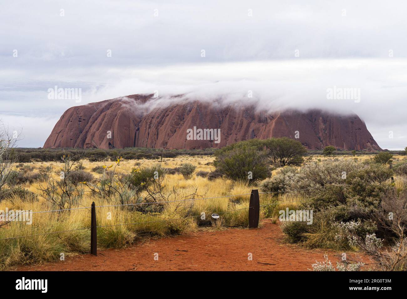 Uluru capped by early morning cloud. Uluru-Kata Tjuta National Park ...